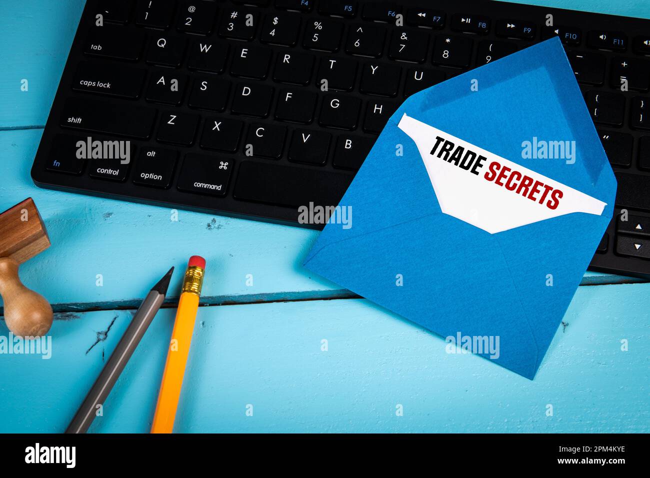 TRADE SECRETS Concept. Letter and computer keyboard on blue office desk ...
