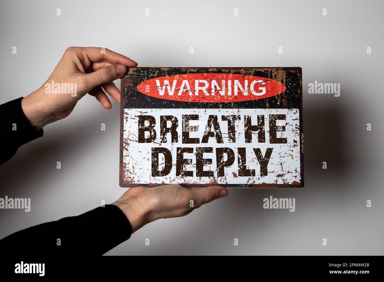 Breathe Deeply. Warning sign with text on a white background in a woman ...