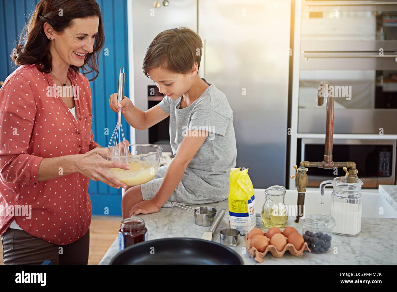 Hes just a little baker boy. a mother baking with her son in the ...