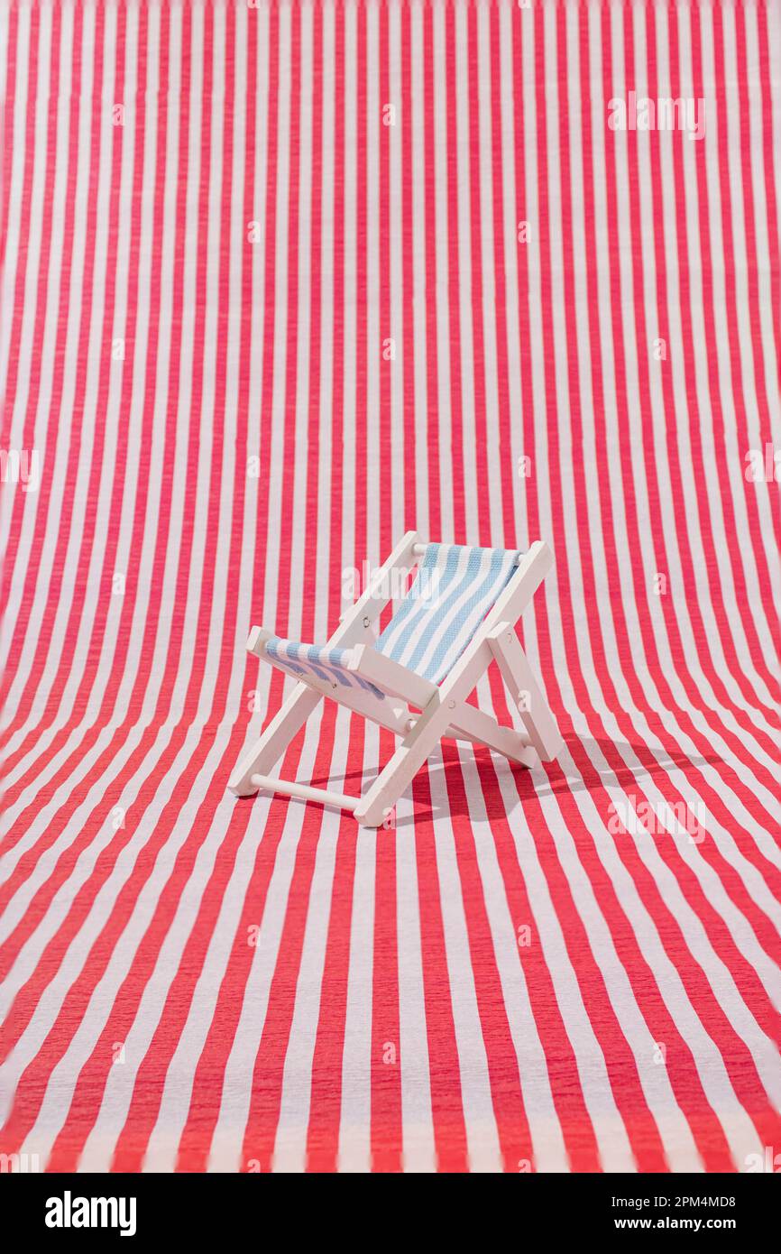 Wooden beach chair on red and white striped background. Minimal summer ...