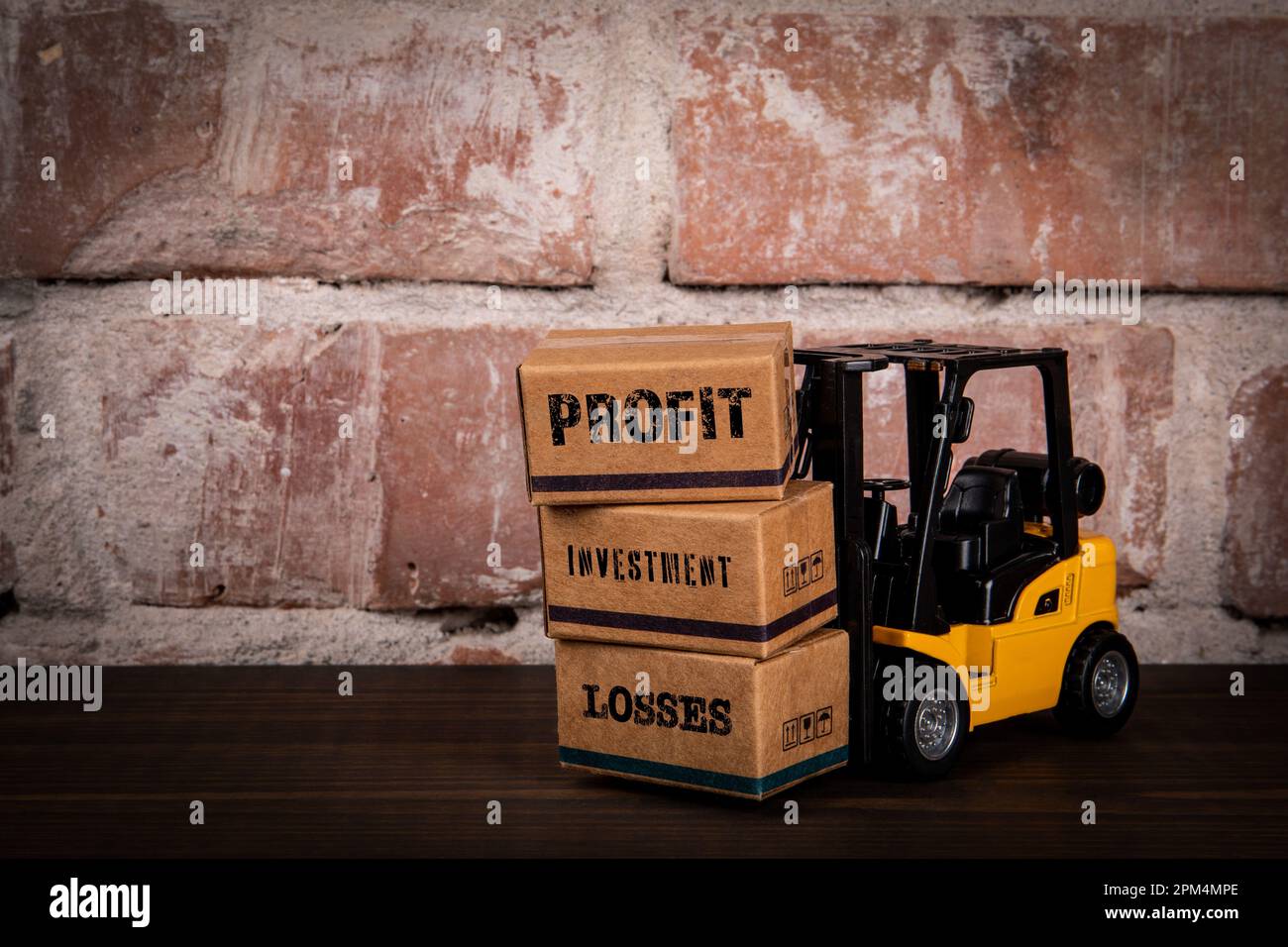 PROFIT LOSS INVESTMENT Concept. Miniature cardboard boxes on a wood and ...