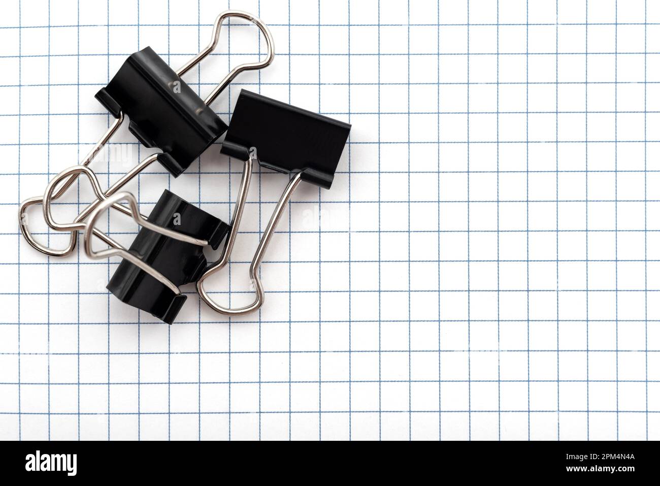 A sheet of paper in a cage for notes with a paper clip on a white ...
