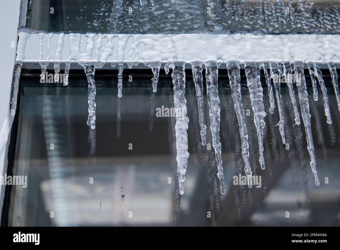 Modern glazed office building. Icicles and ice, thaw Stock Photo - Alamy