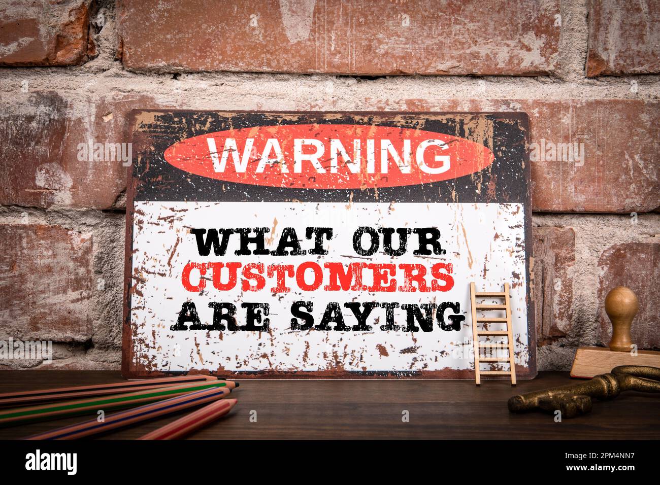 What Our Customers Are Saying. Warning sign with text on wooden shelf ...