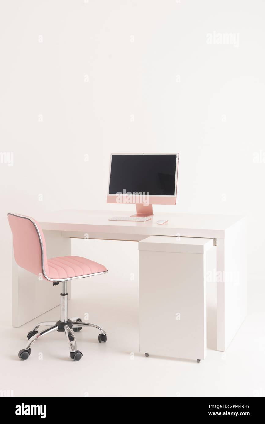 England, UK. 2023. An office, pink desk, pink chair and pink computer ...