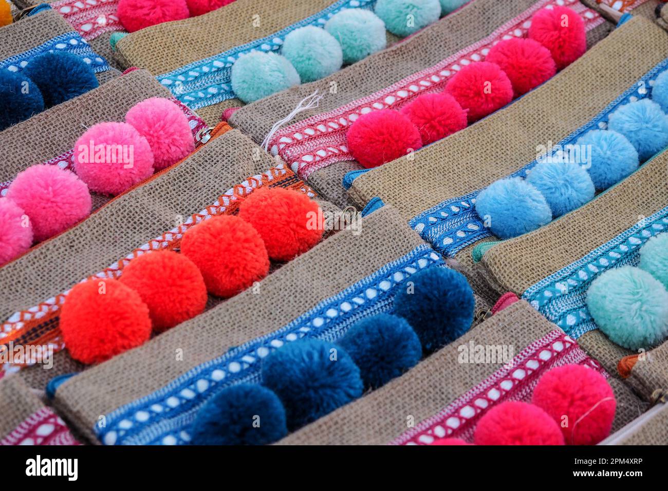 Small textile purses with colourful pompoms on display at street market ...