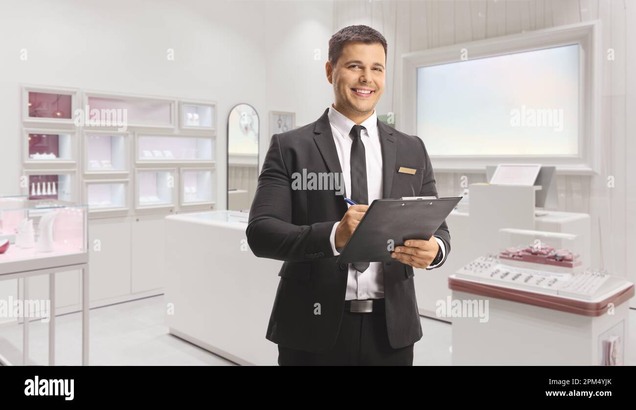 Jewelry shop manager holding a document inside a shop Stock Photo - Alamy