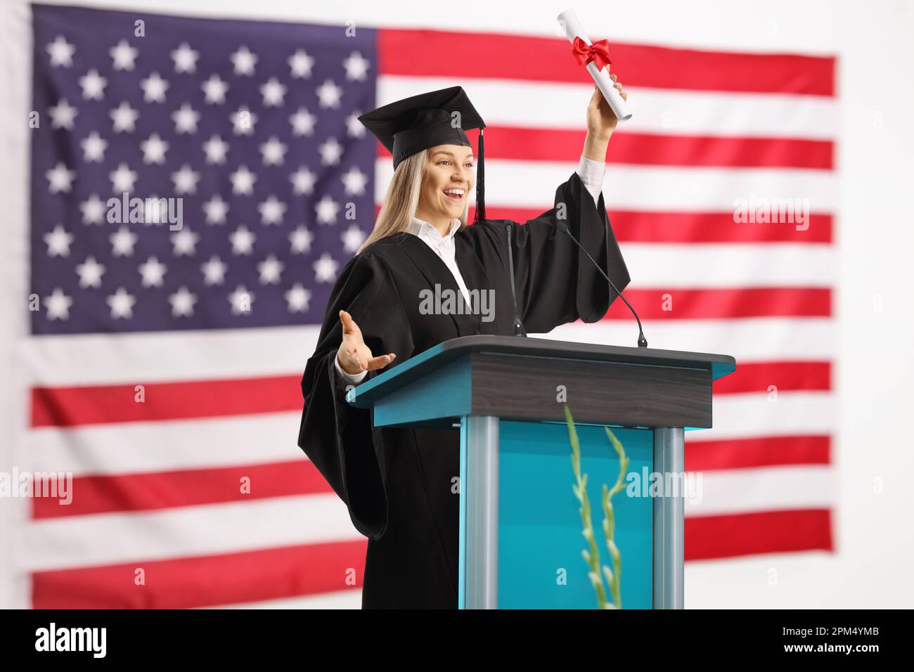 Female student of honor holding a certificate at a podium in front of ...