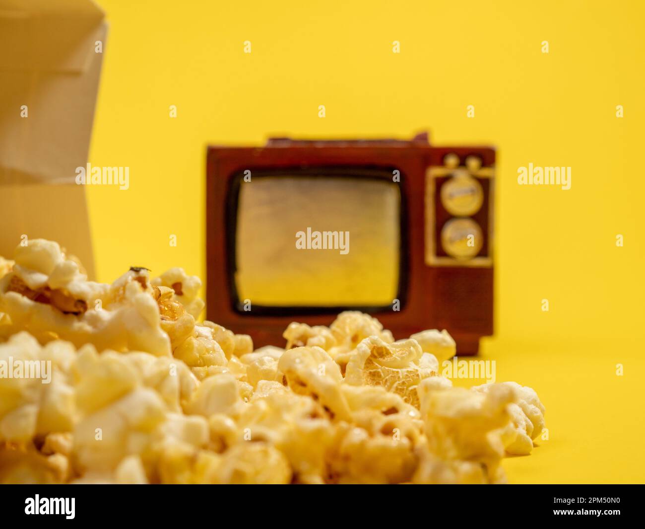 Popcorn and old TV on a yellow background. Sweet popcorn on yellow ...