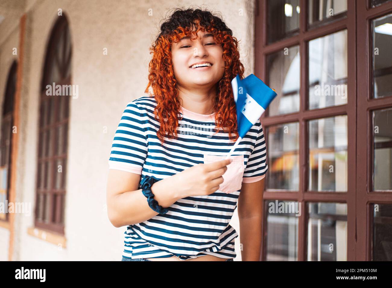 Portrait of a young latin american woman with colorful hair looking at ...
