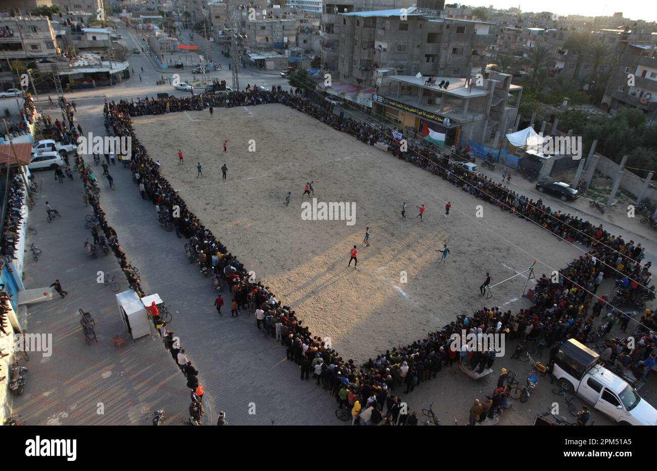 Palestinians watch youths play in a local football match in Popular ...