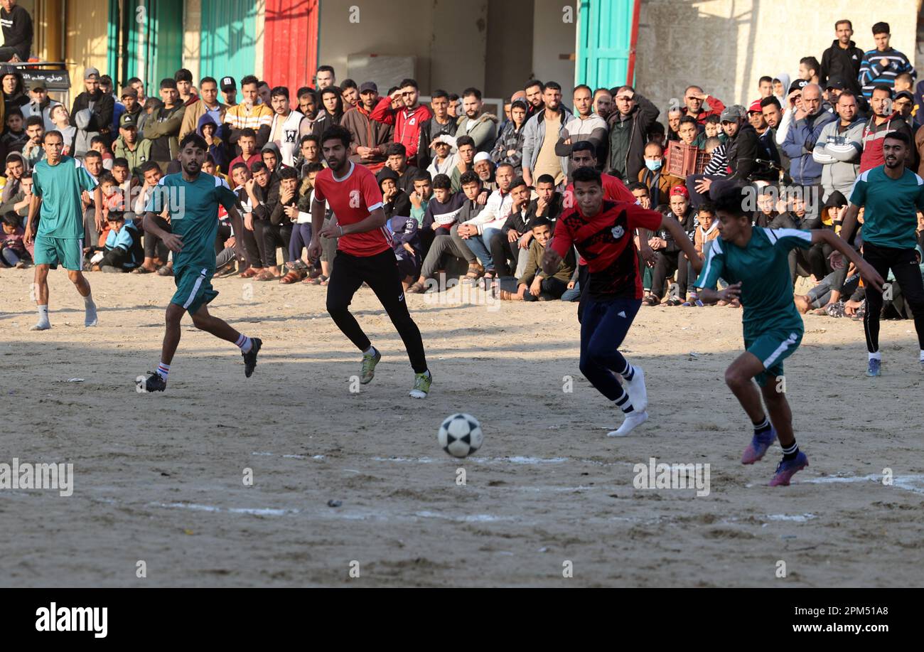 Palestinians watch youths play in a local football match in Popular ...