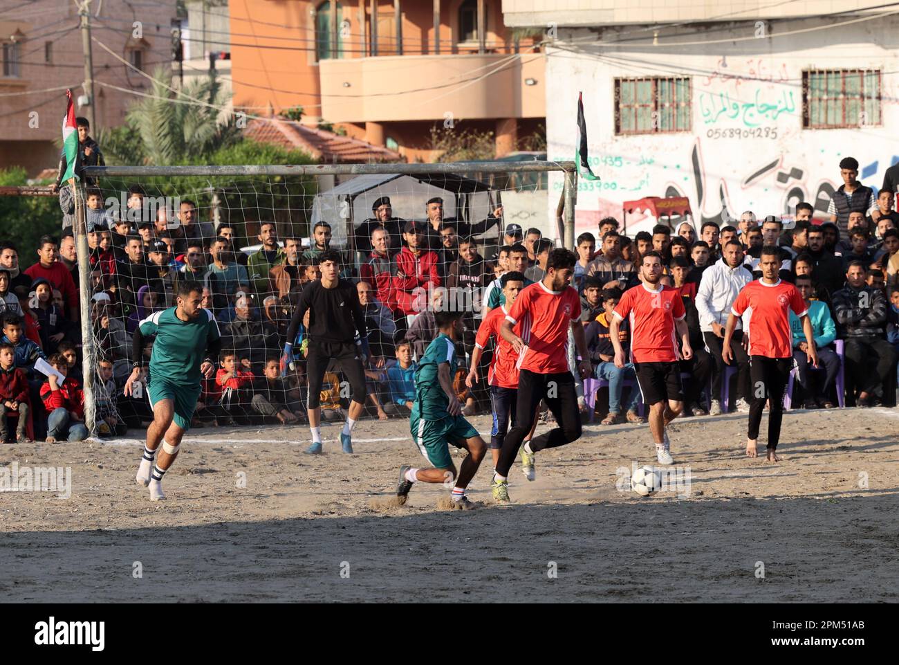 Palestinians watch youths play in a local football match in Popular ...