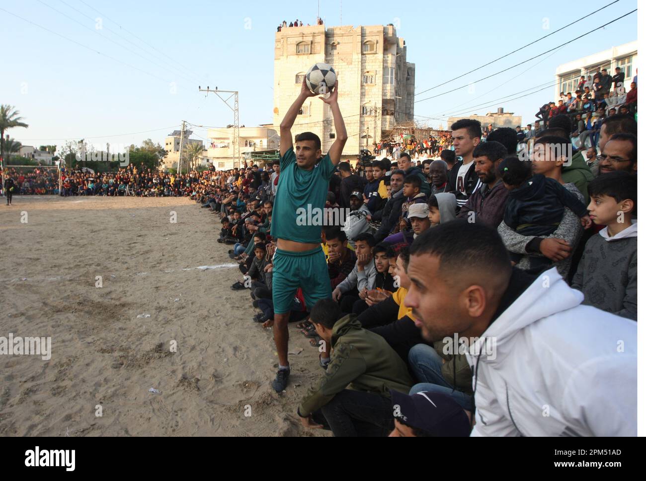 Palestinians watch youths play in a local football match in Popular ...