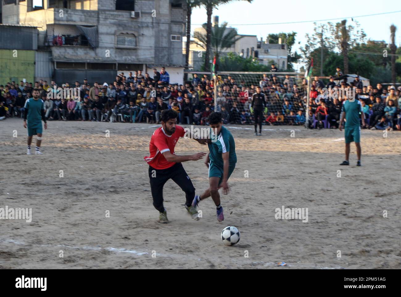 Palestinians watch youths play in a local football match in Popular ...