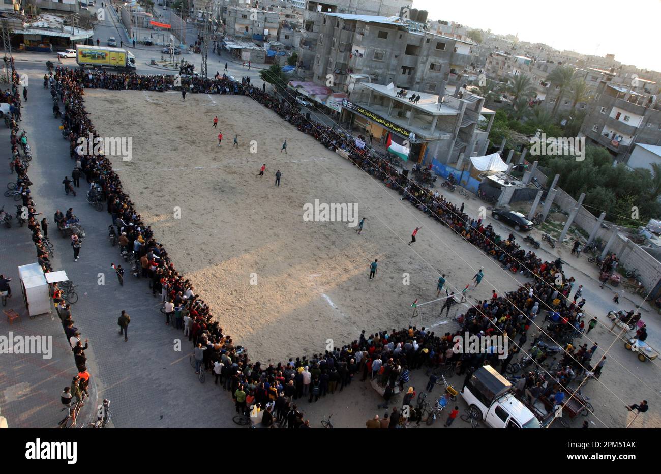 Palestinians watch youths play in a local football match in Popular ...