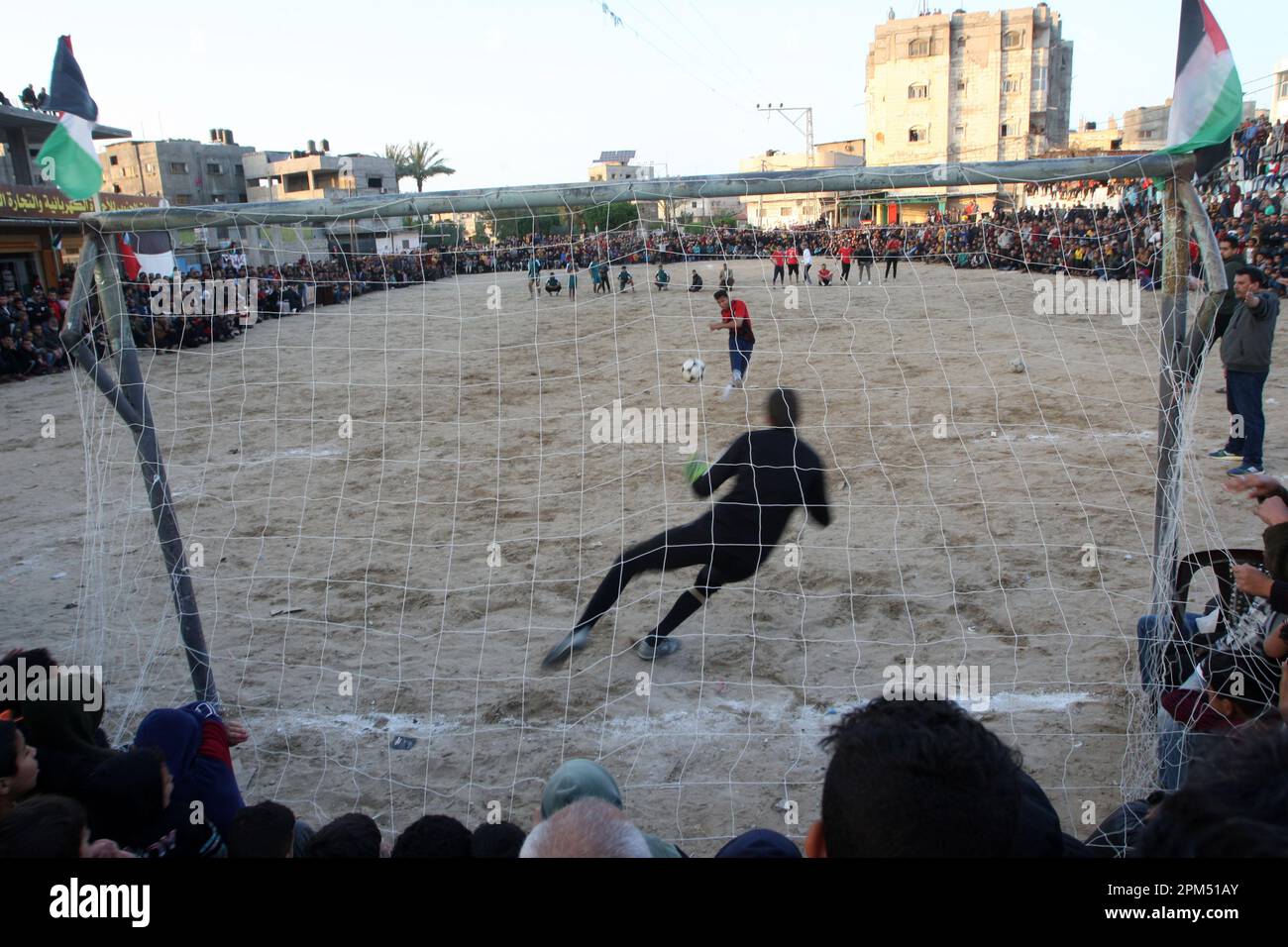Palestinians watch youths play in a local football match in Popular ...