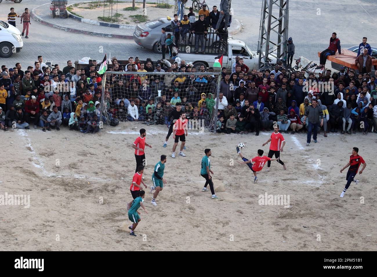 Palestinians watch youths play in a local football match in Popular ...