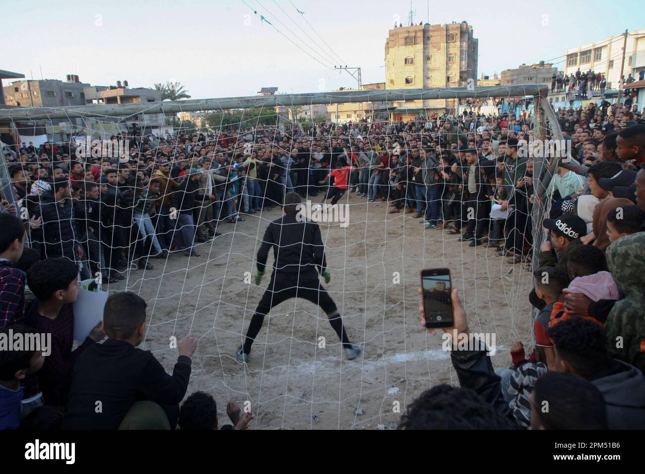 Palestinians watch youths play in a local football match in Popular ...