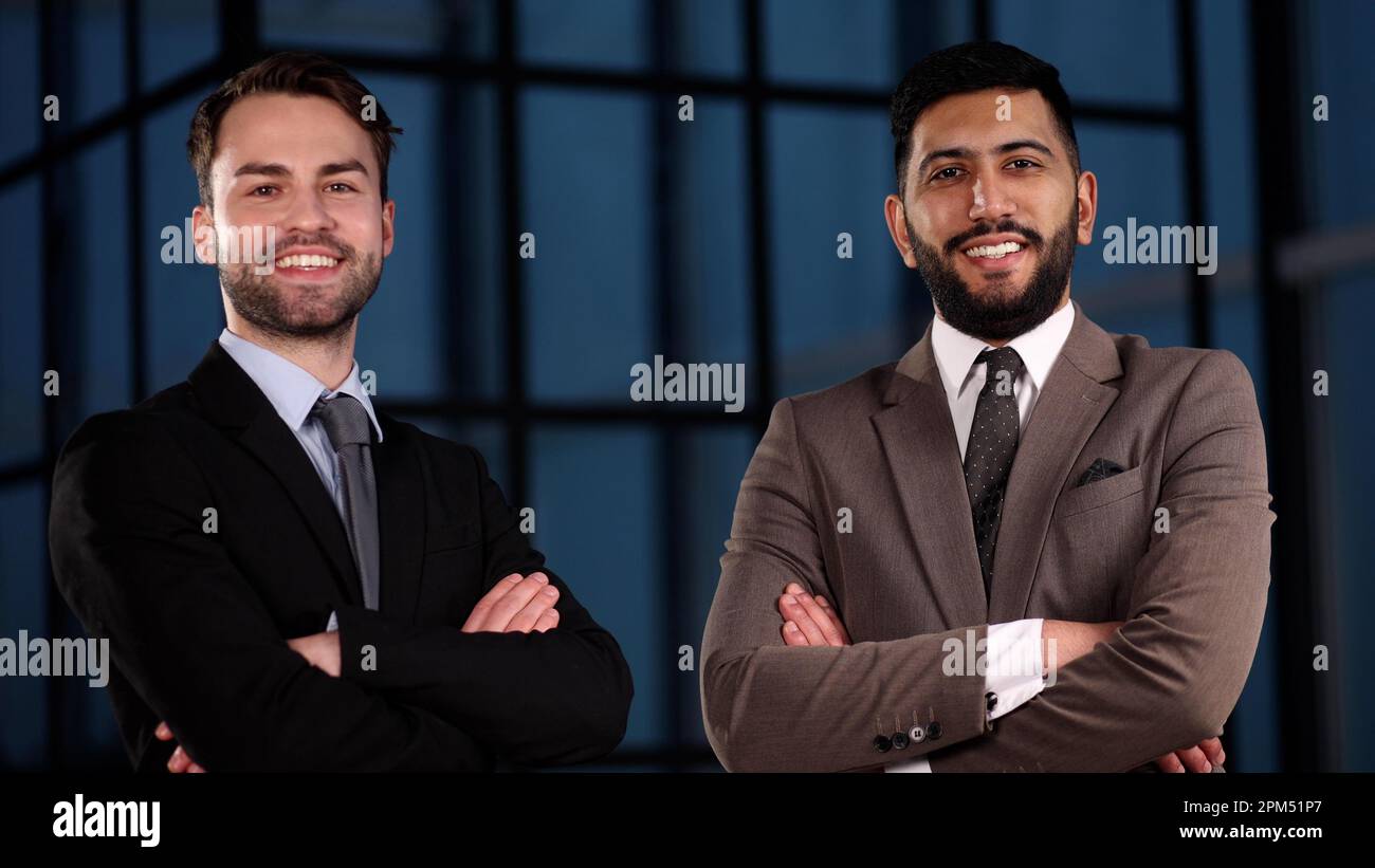 Portrait of a two smiling young men standing with arms Stock Photo - Alamy