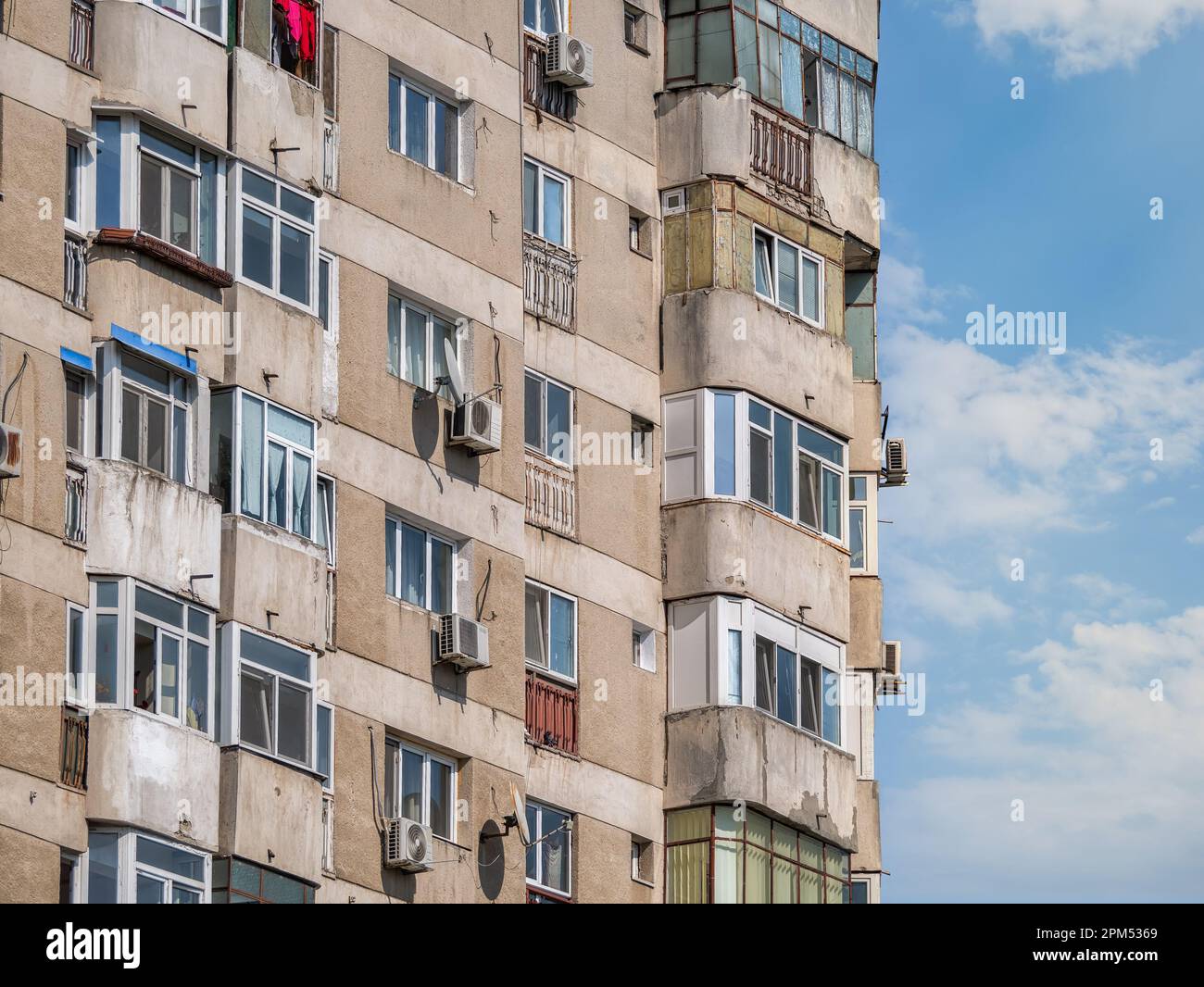 Worn out apartment building from the communist era against blue sky in ...
