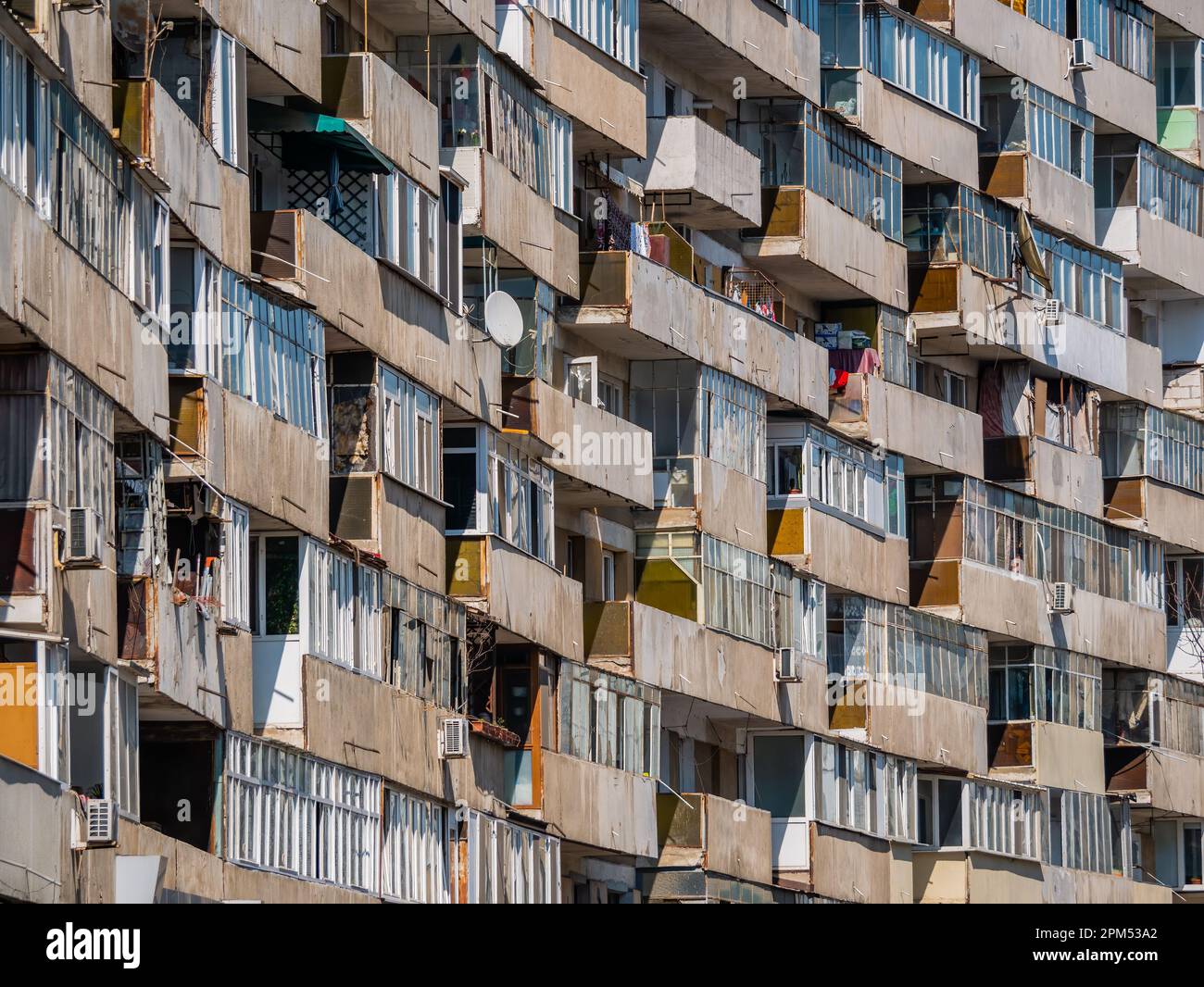 Worn out apartment building from the communist era against blue sky in ...