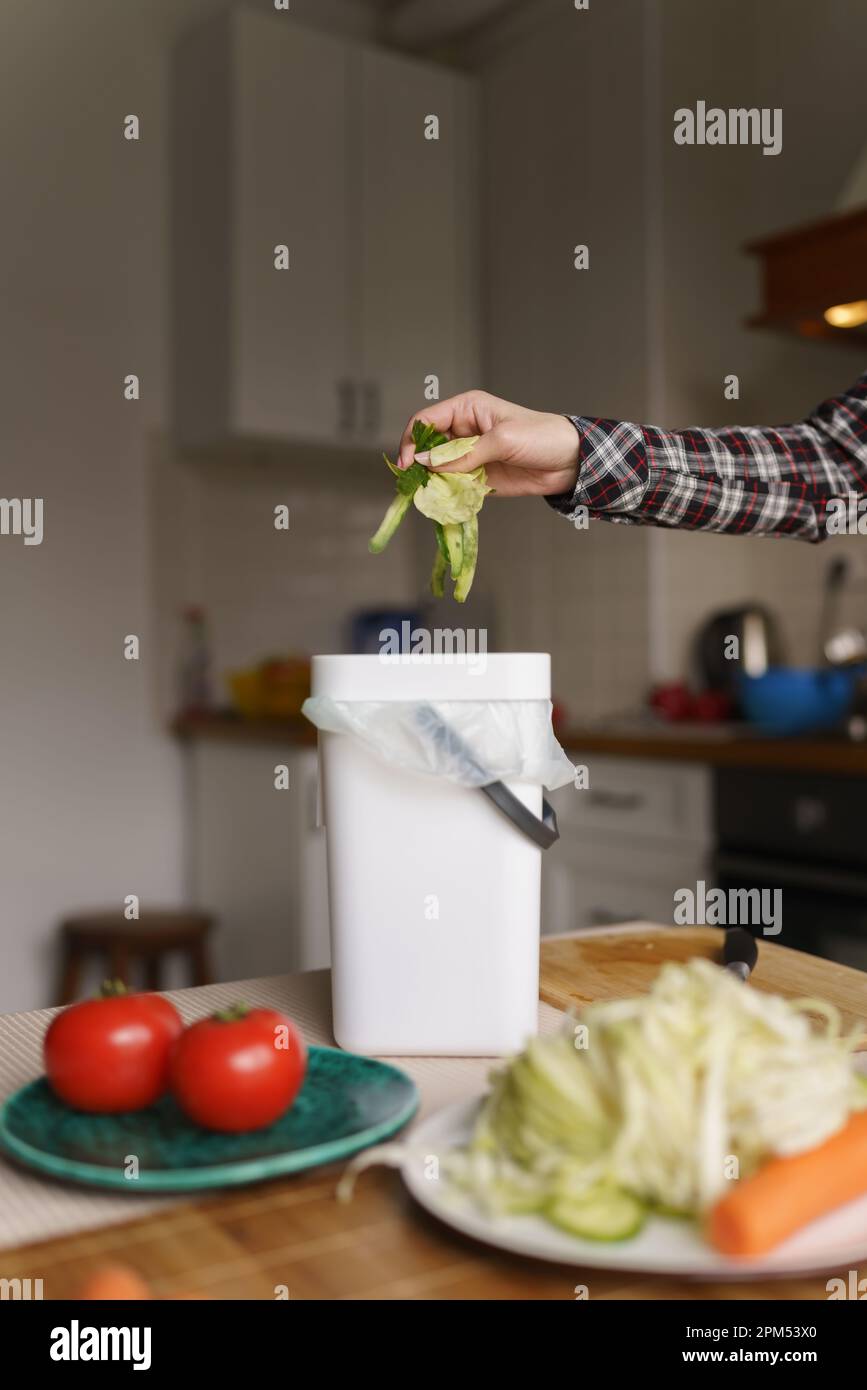 Female hand throwing food leftovers in a compost container with bokashi ...