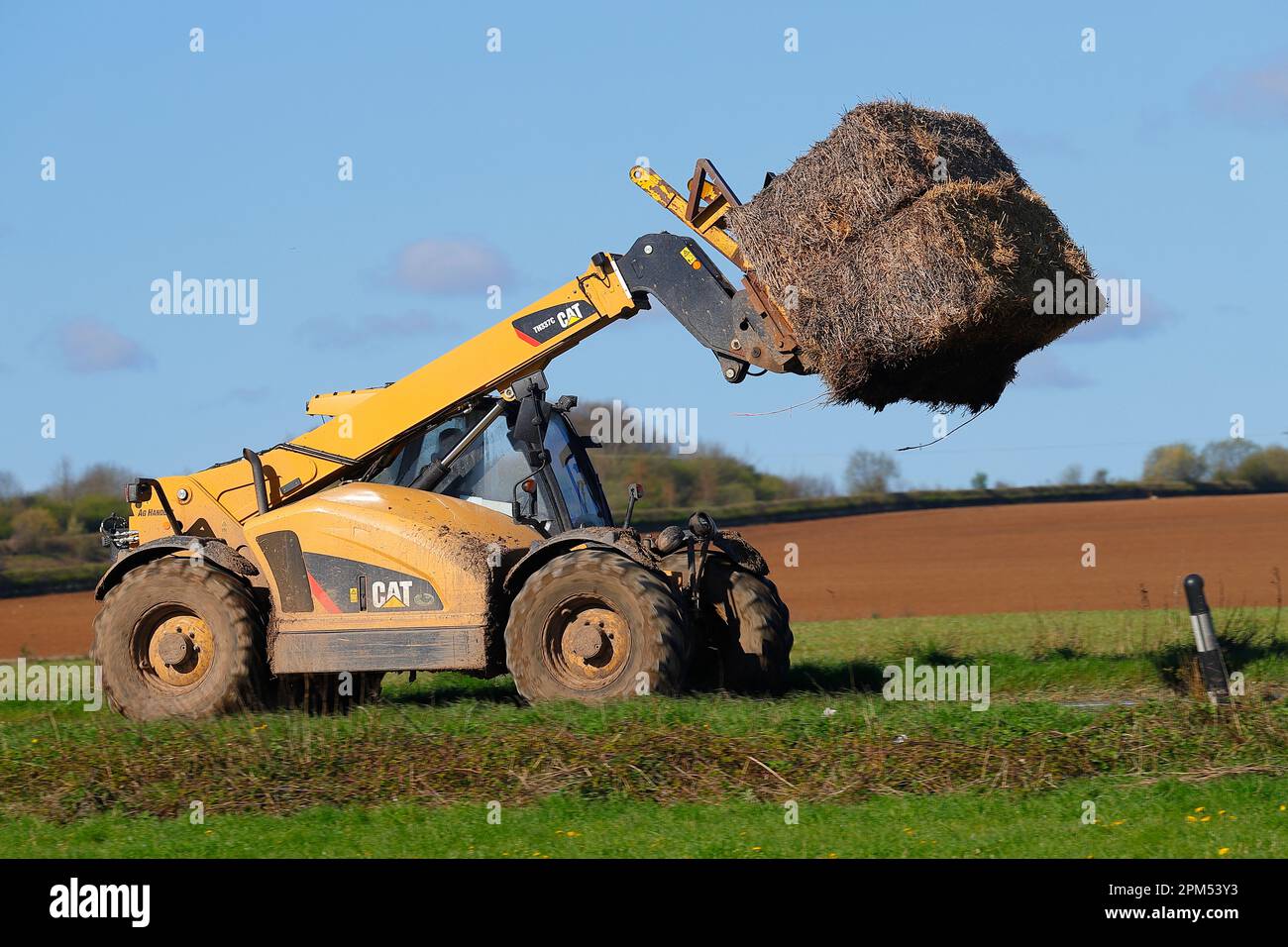 A Caterpillar telescopic handler TH337C travelling along the B1222 near ...