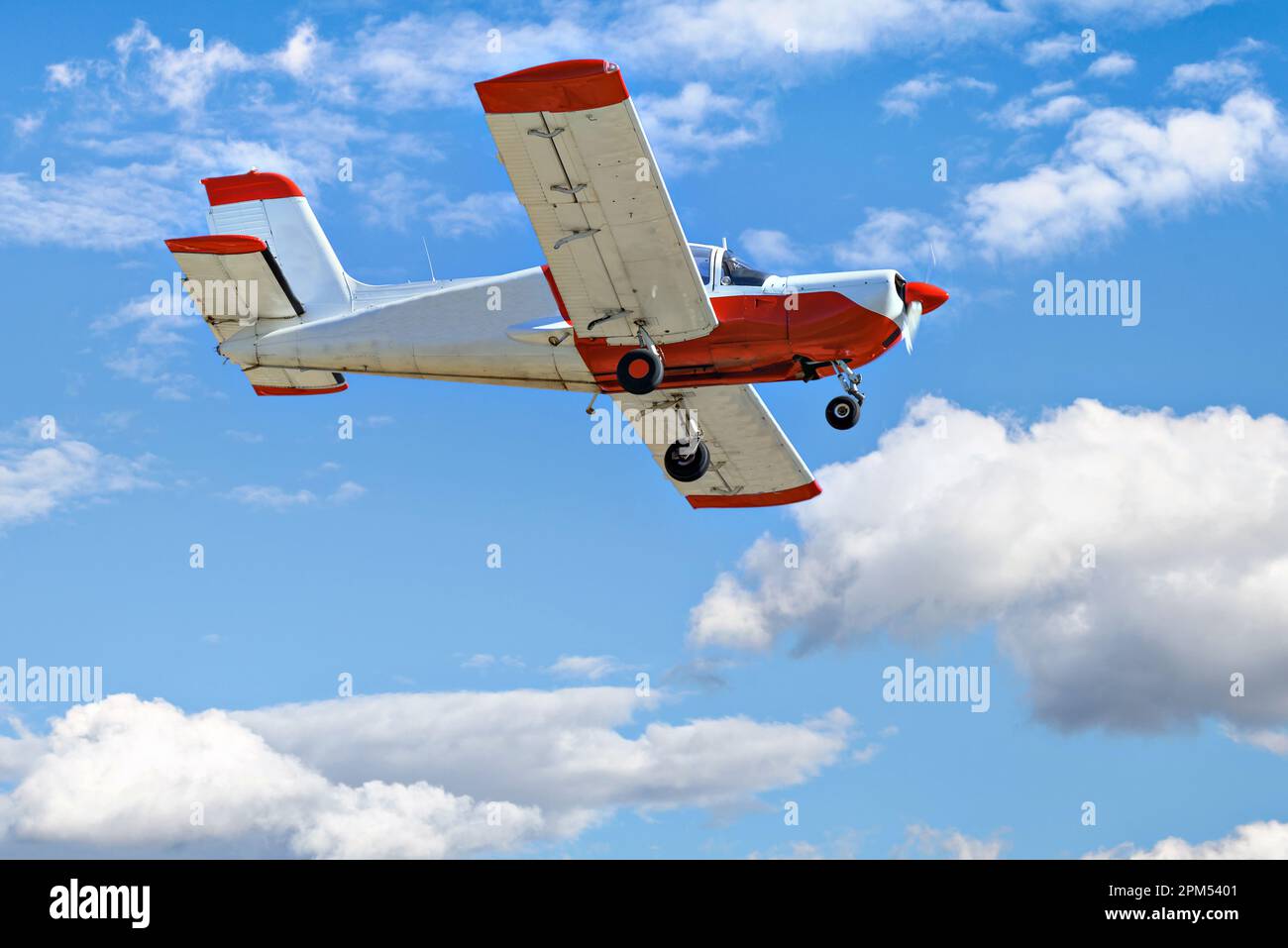 Single engine ultralight plane flying in the blue sky with white clouds ...