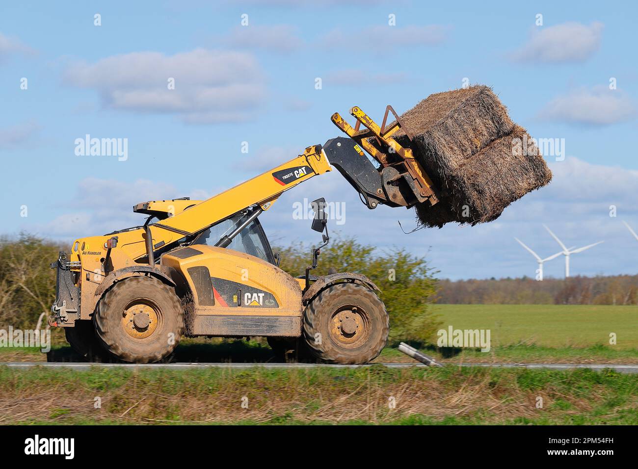 A Caterpillar telescopic handler TH337C travelling along the B1222 near ...
