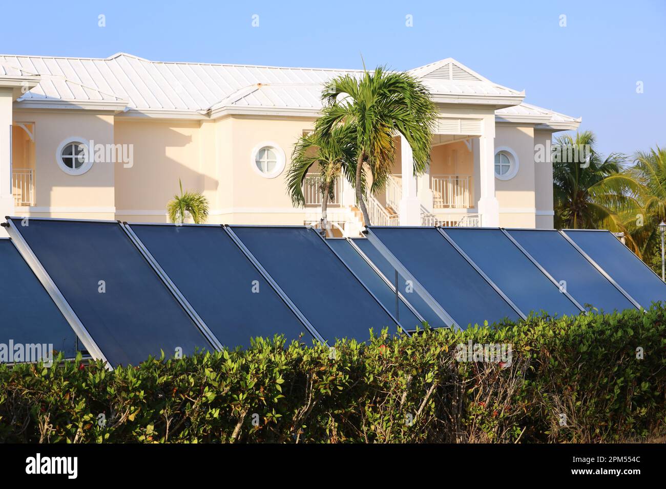 Solar panels on background of villa and palm trees. Clean ecological ...