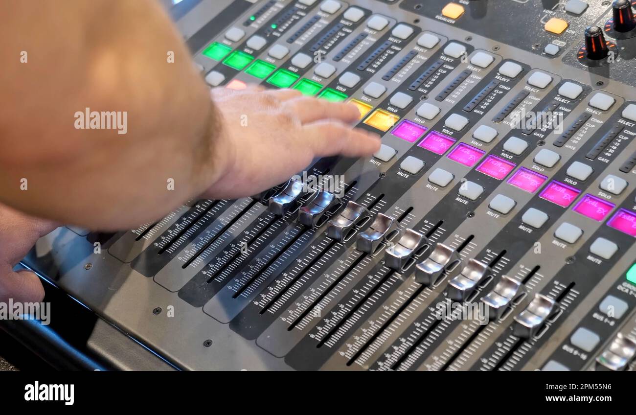 A male sound engineering running live sound for a local band on a ...