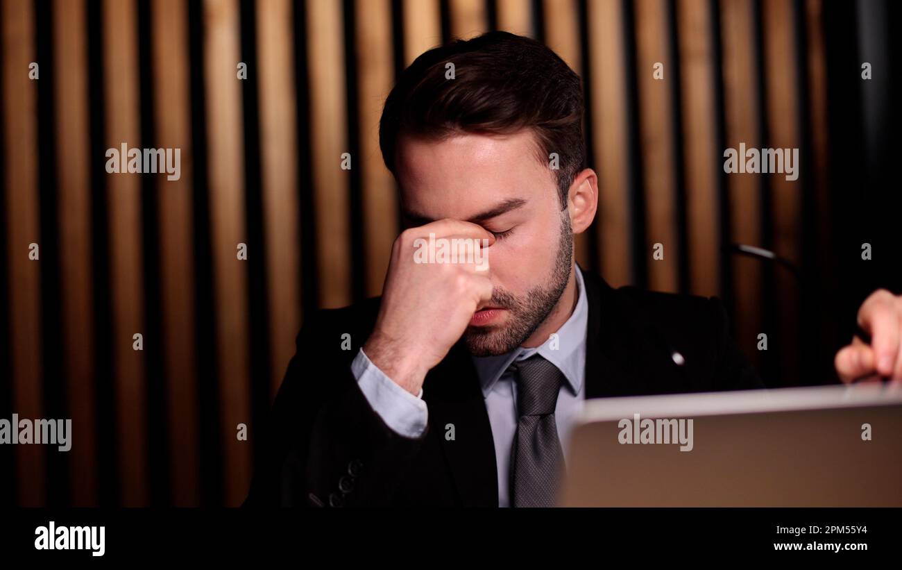 Tired man behind a computer screen from boring routine work in the ...