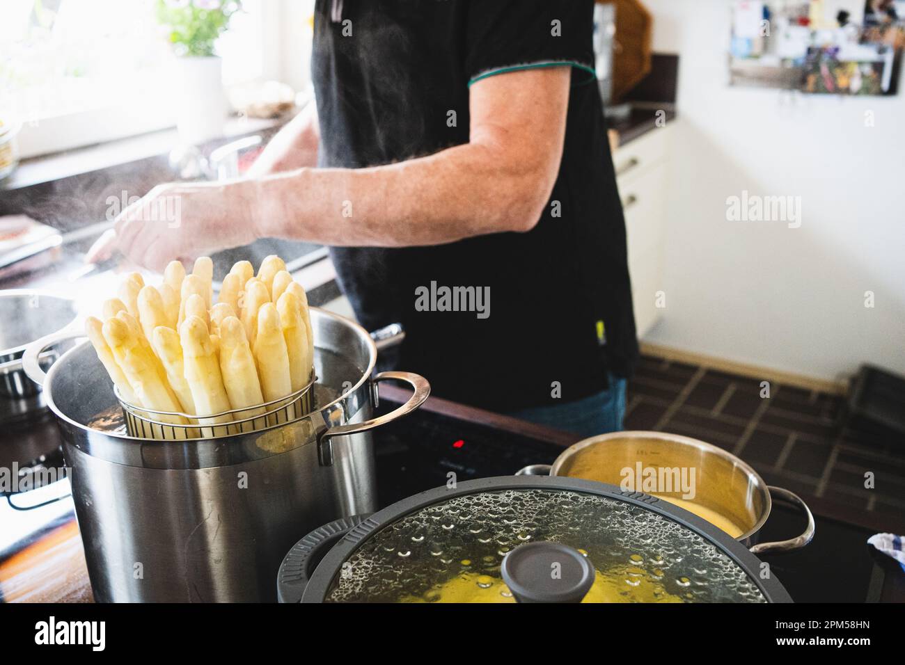 old man cooking asparagus in the kitchen Stock Photo - Alamy