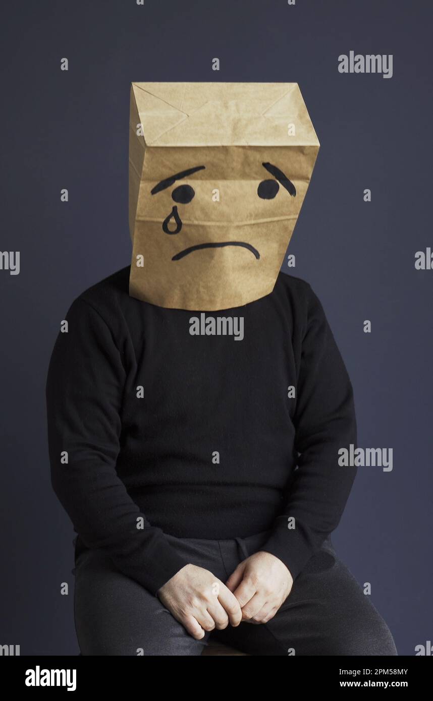 A sad man in a black turtleneck with a bag on his head, with a drawn ...