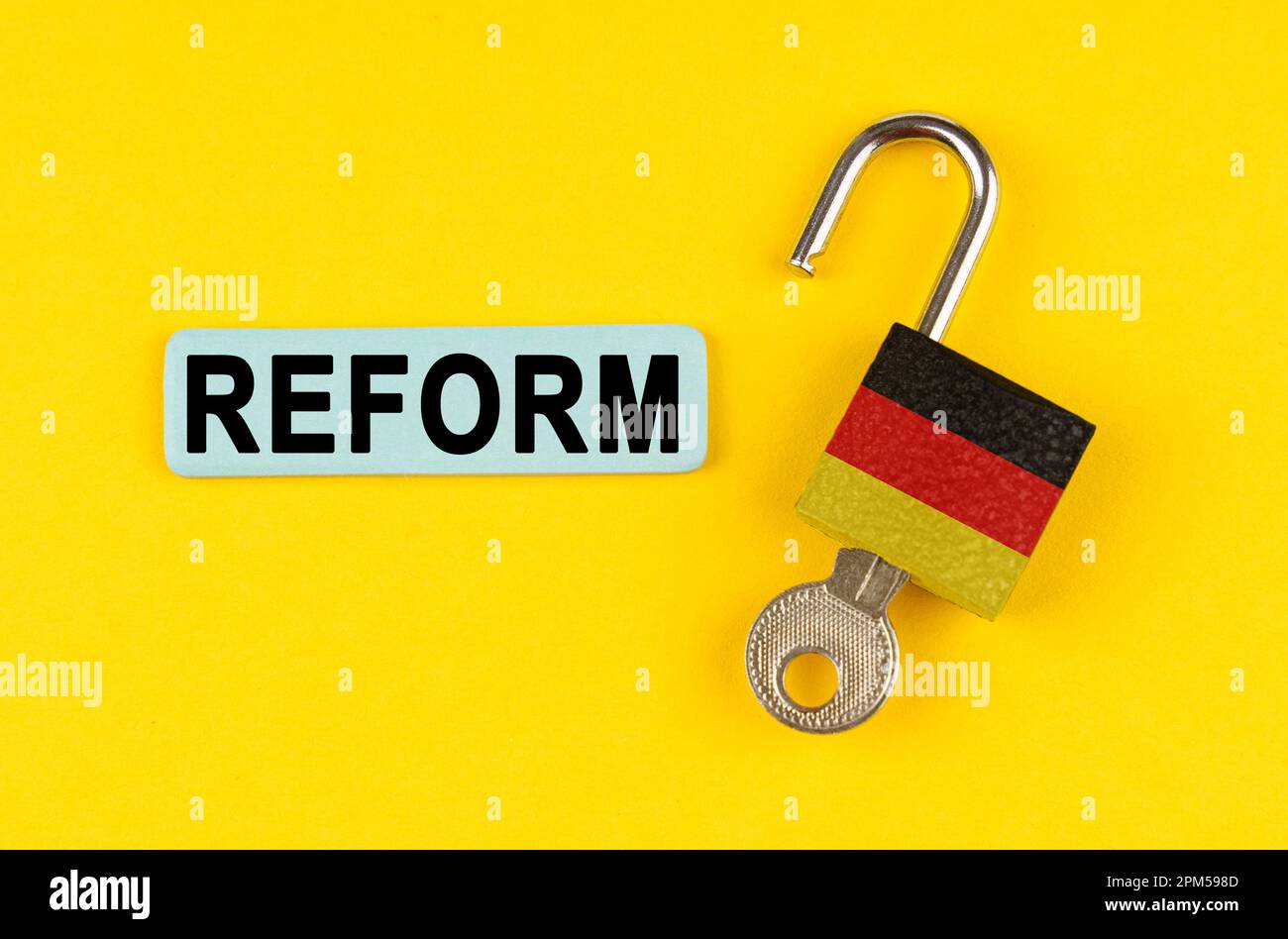 On a yellow surface, an open lock with the image of the flag of Germany ...