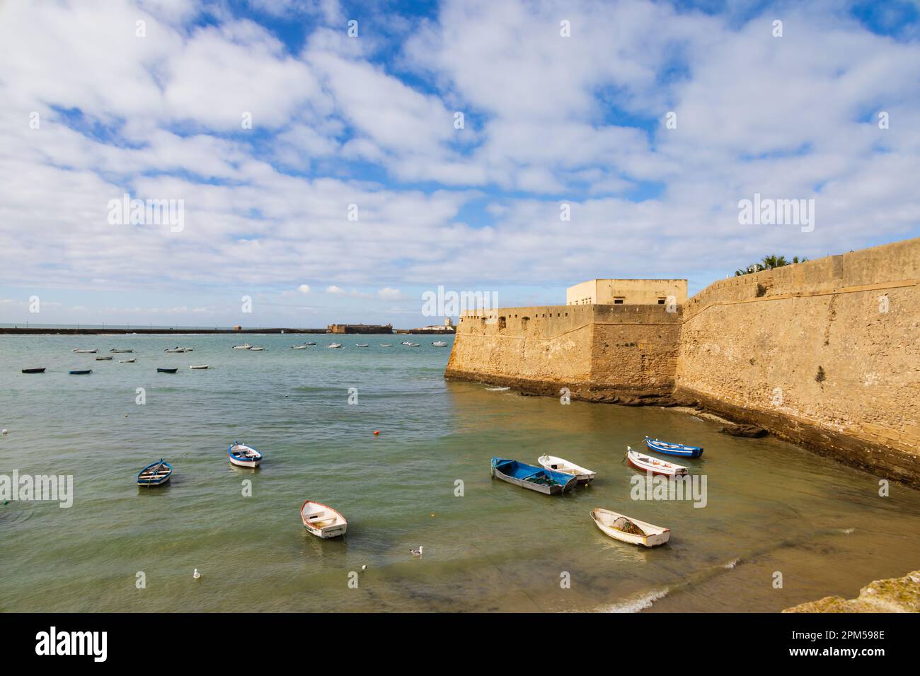 Boats anchored below the walls of Castillo de Santa Catalina fort ...