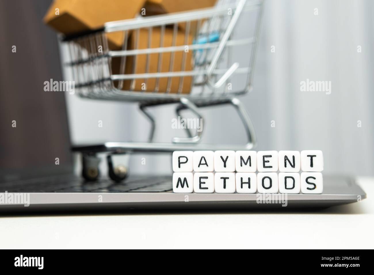 Payment methods words on cubes with a toy shopping cart and cardboard ...