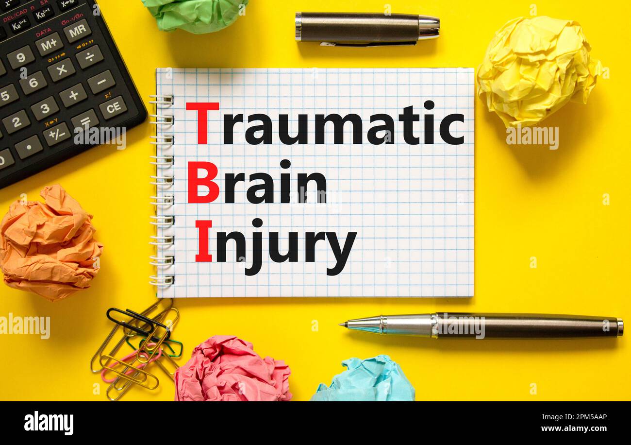 TBI traumatic brain injury symbol. Concept words TBI traumatic brain injury on white note on a ...