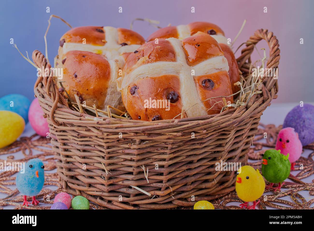 Easter basket with hot cross buns and some chicks and eggs around it ...