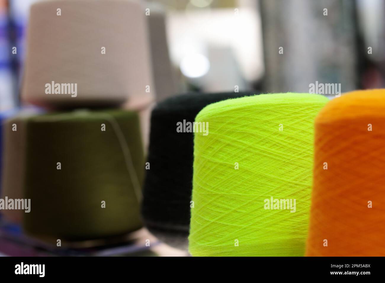 Multi-colored wool yarn cones for textile industry. Selective focus ...