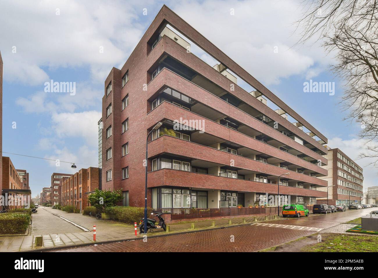 a red brick building in the middle of an urban area with cars parked on ...