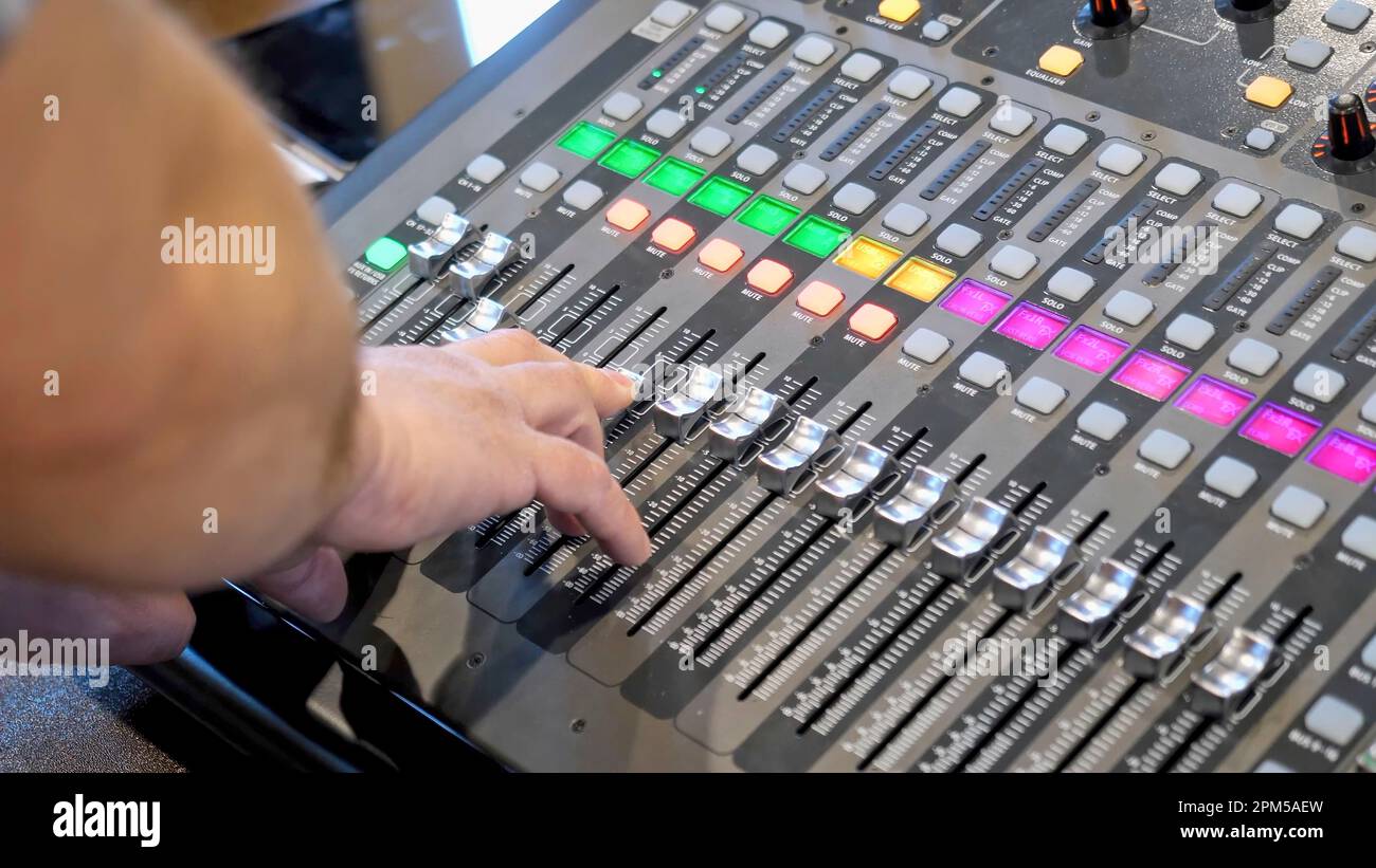 A male sound engineering running live sound for a local band on a ...