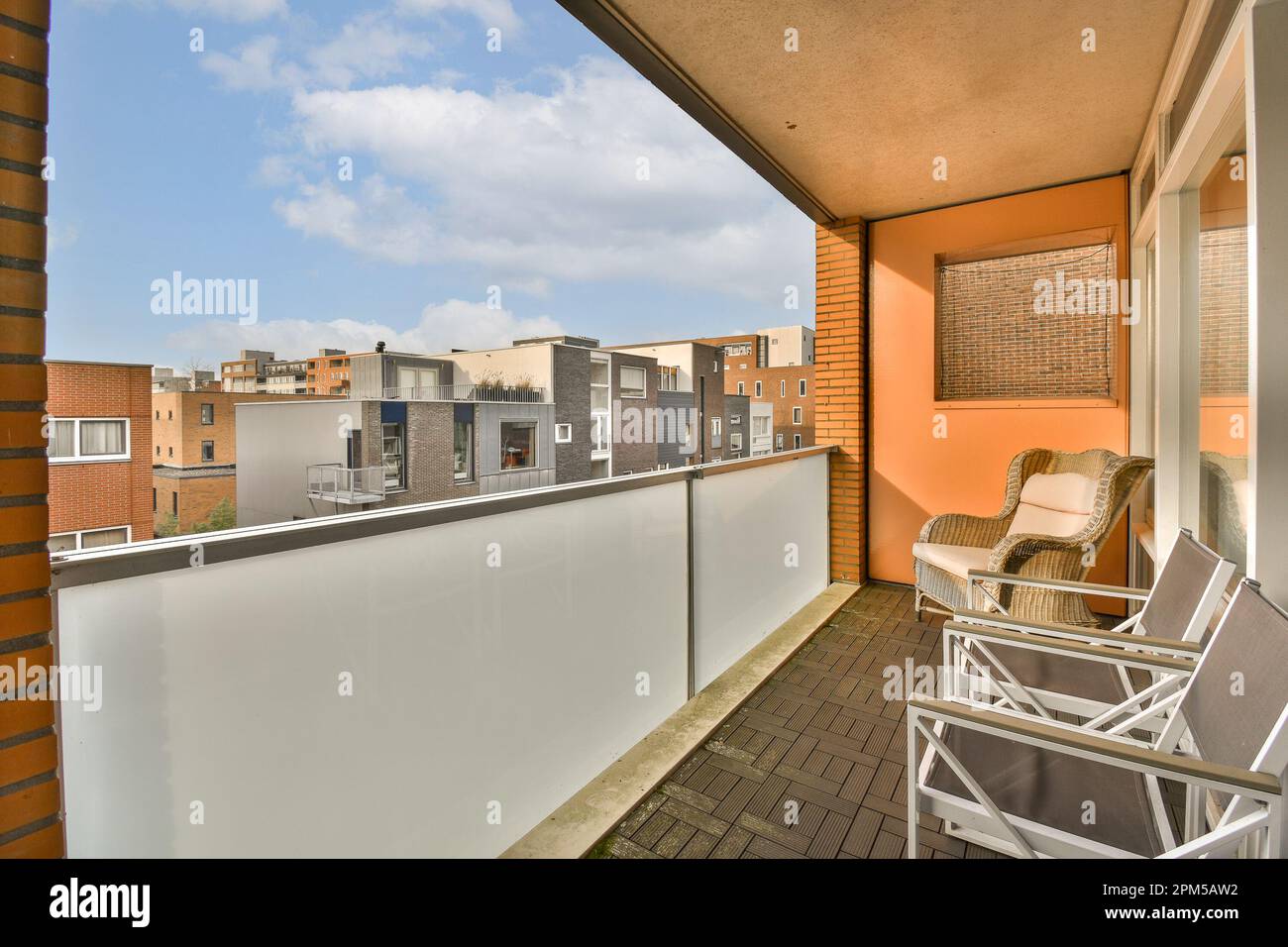 a balcony with two chairs and a table on the left side, looking out to ...