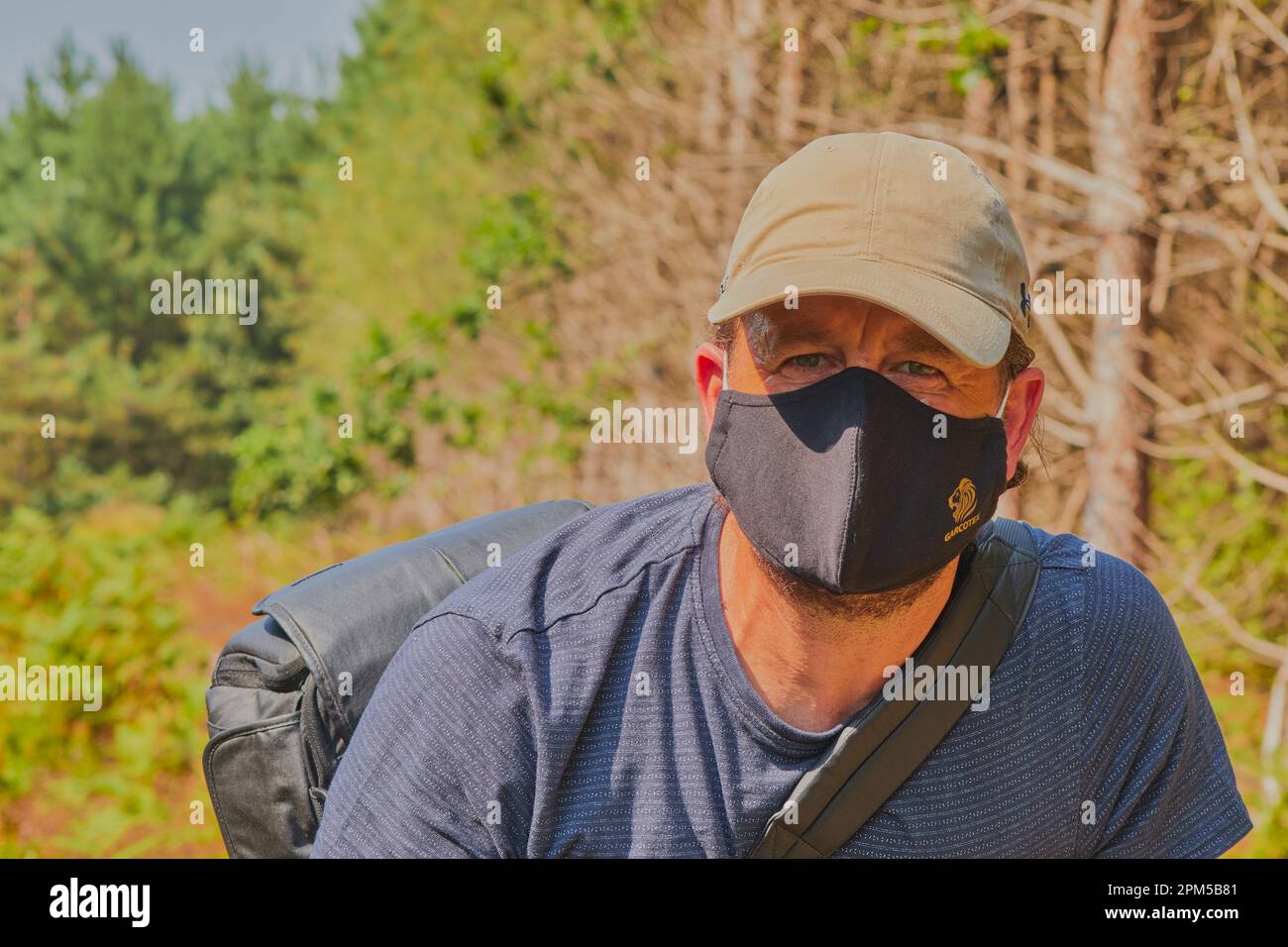 Man out hiking in the woods with a covid face mask on for protection ...