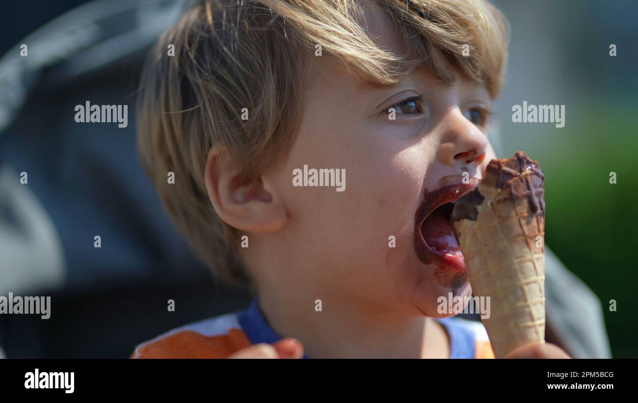 Child eating ice cream cone snack. Kid portrait face eats dessert Stock ...