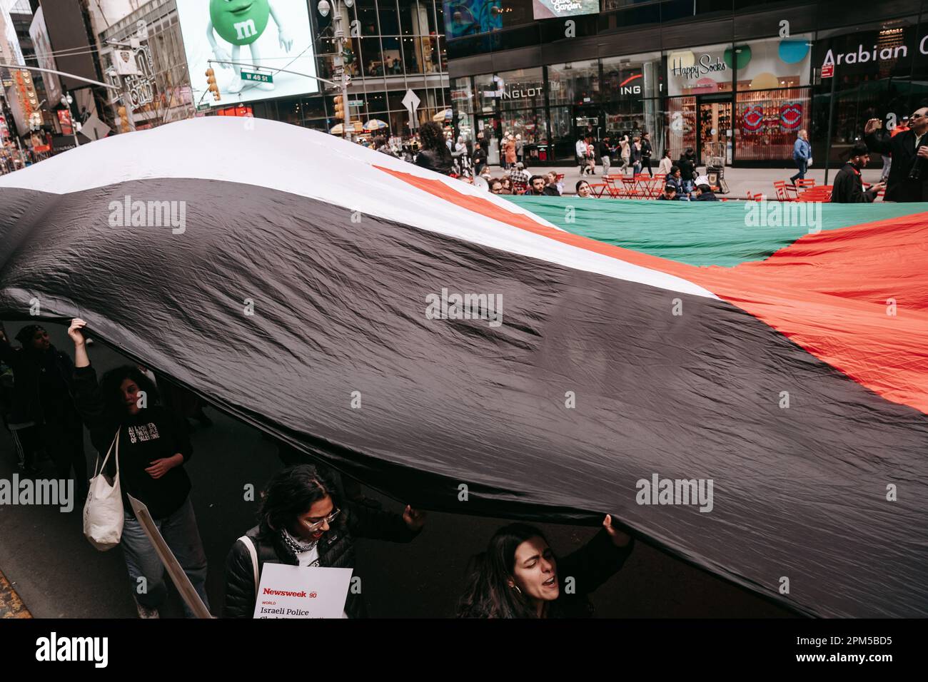 New York, USA. 8th Apr, 2023. Marchers carry a large Palestinian flag ...