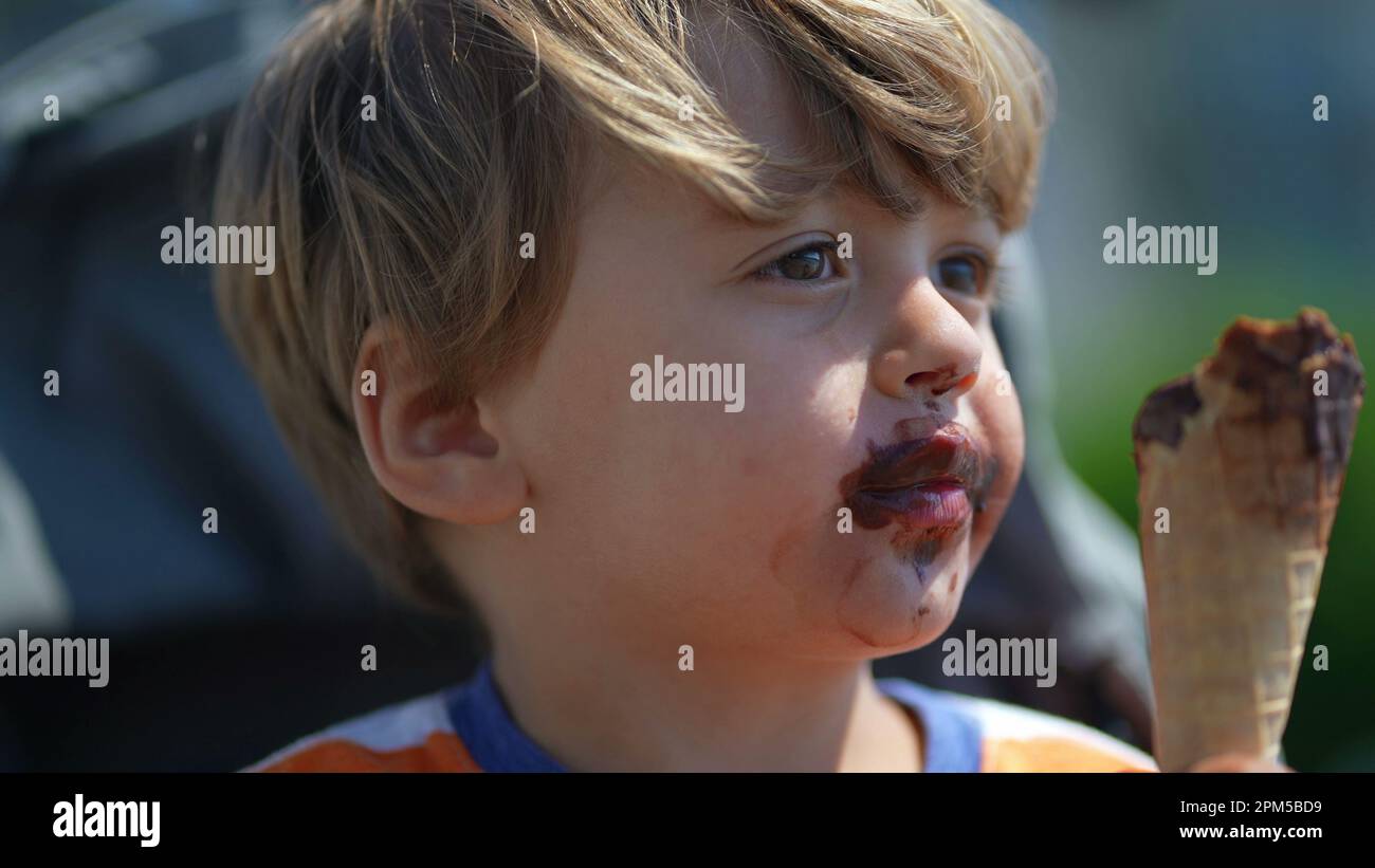 Child eating ice cream cone snack. Kid portrait face eats dessert Stock ...