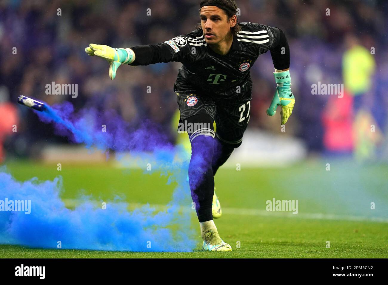 Bayern Munich goalkeeper Yann Sommer removes a blue flare from the ...