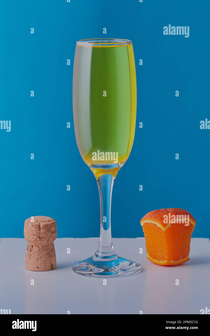 Cocktail in a flute glass with a blue background Stock Photo - Alamy